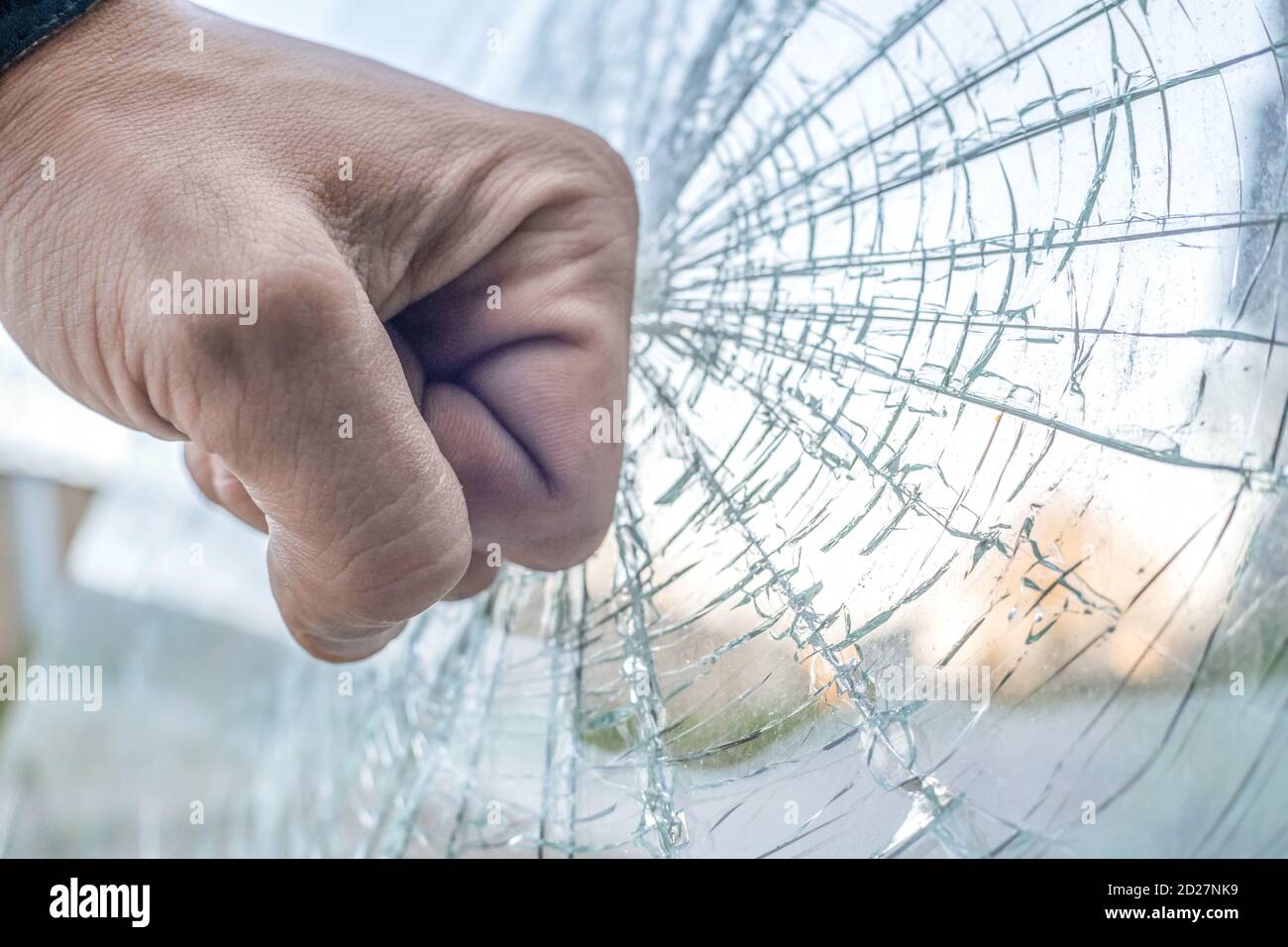 male shot a fist into the windshield of the car. Cracks on the ...