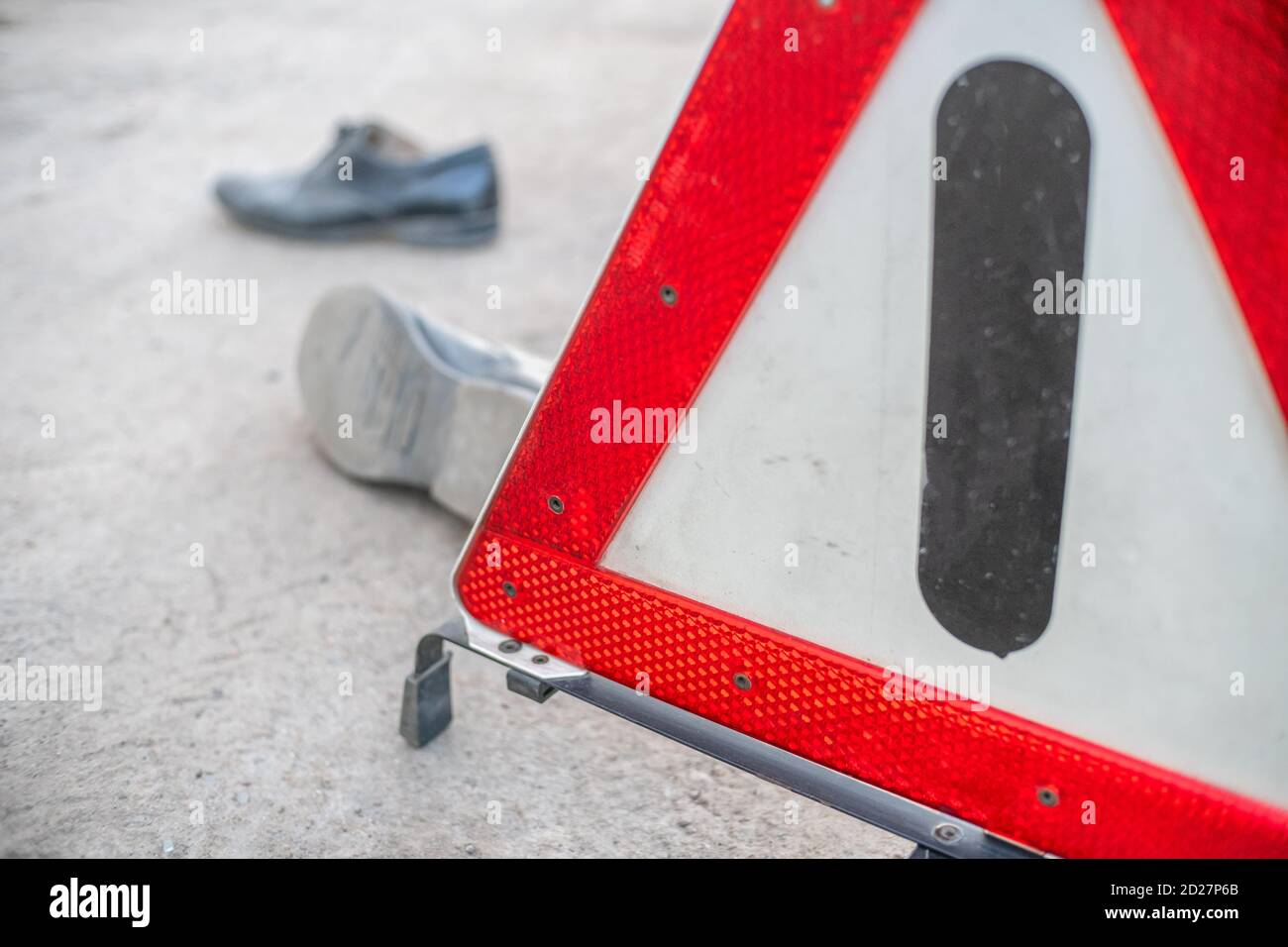 An accident on the road involving a person. Close up of a man's boot ...