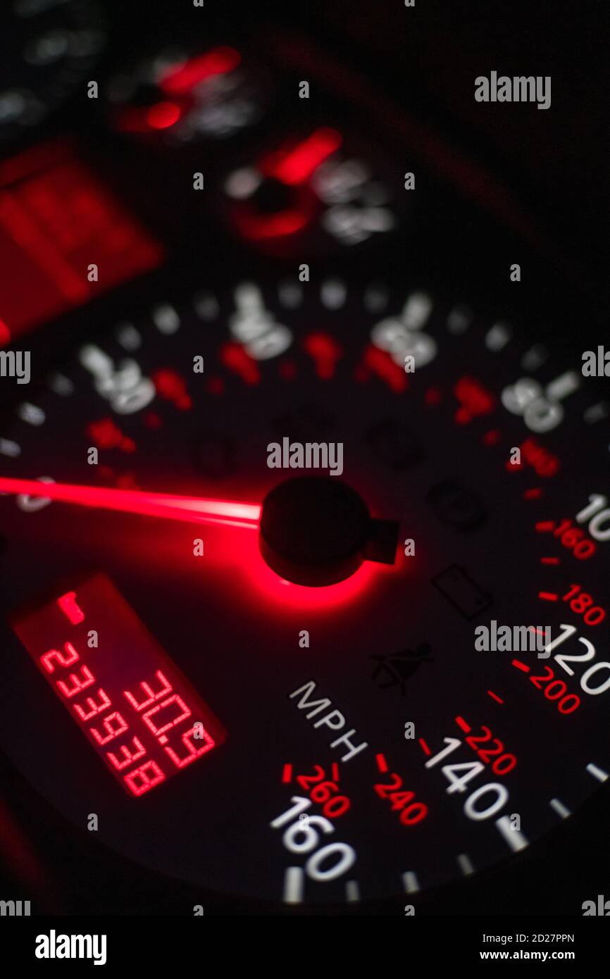 car dashboard. Speedometer with red backlight at night close up ...