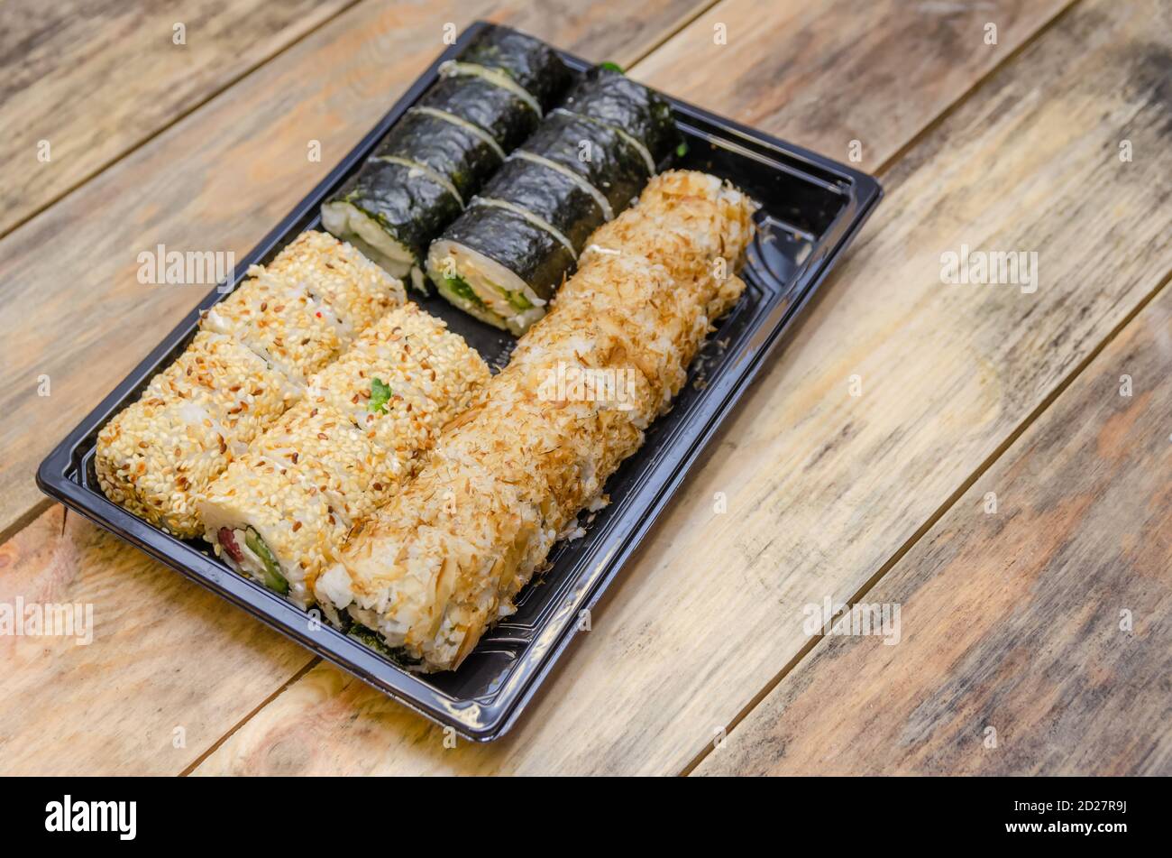 Set sushi Toto Maki, Bonito Maki, Akito Maki on a wooden background ...