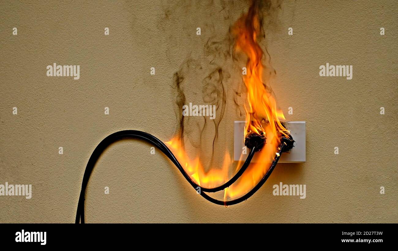 On fire electric wire plug Receptacle on the concrete wall background ...