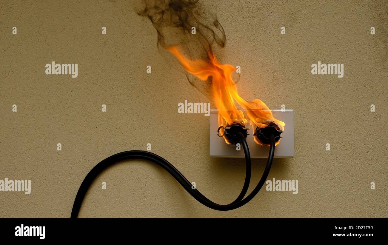 On fire electric wire plug Receptacle on the concrete wall background ...