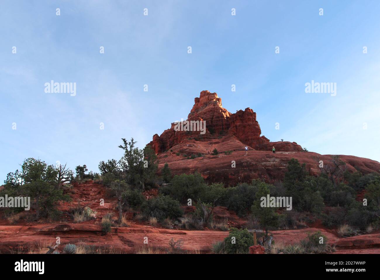 Hikers climbing Bell Rock, a red sanddstone geologic formation, in ...