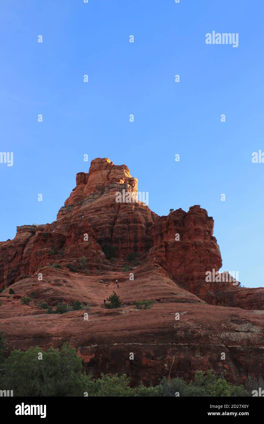 Hikers climbing Bell Rock, a red sanddstone geologic formation, in ...