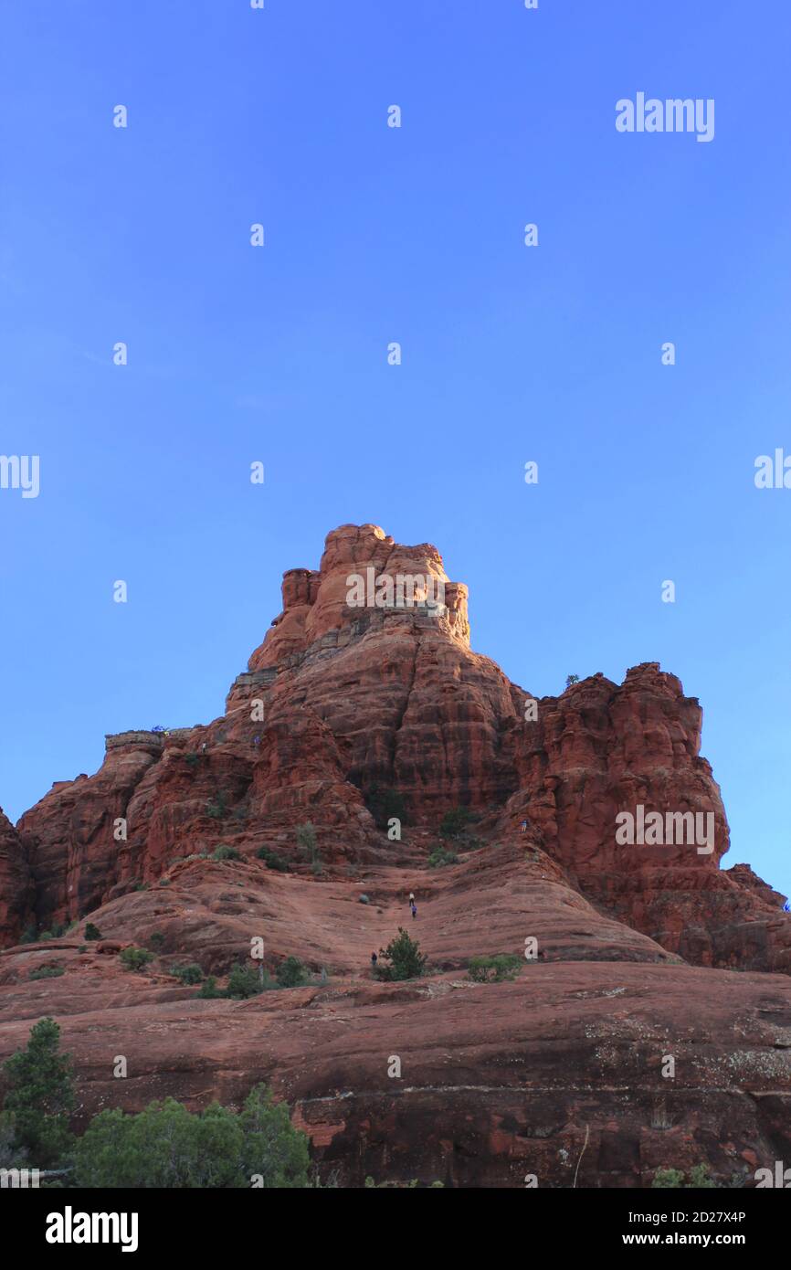 Hikers climbing Bell Rock, a red sanddstone geologic formation, in ...
