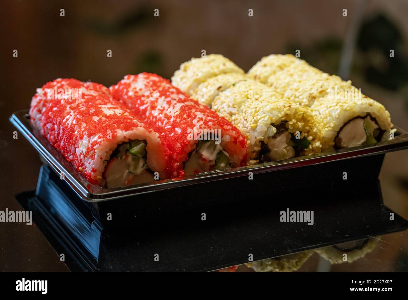 Assorted sushi (red and white) on a black background with reflection ...