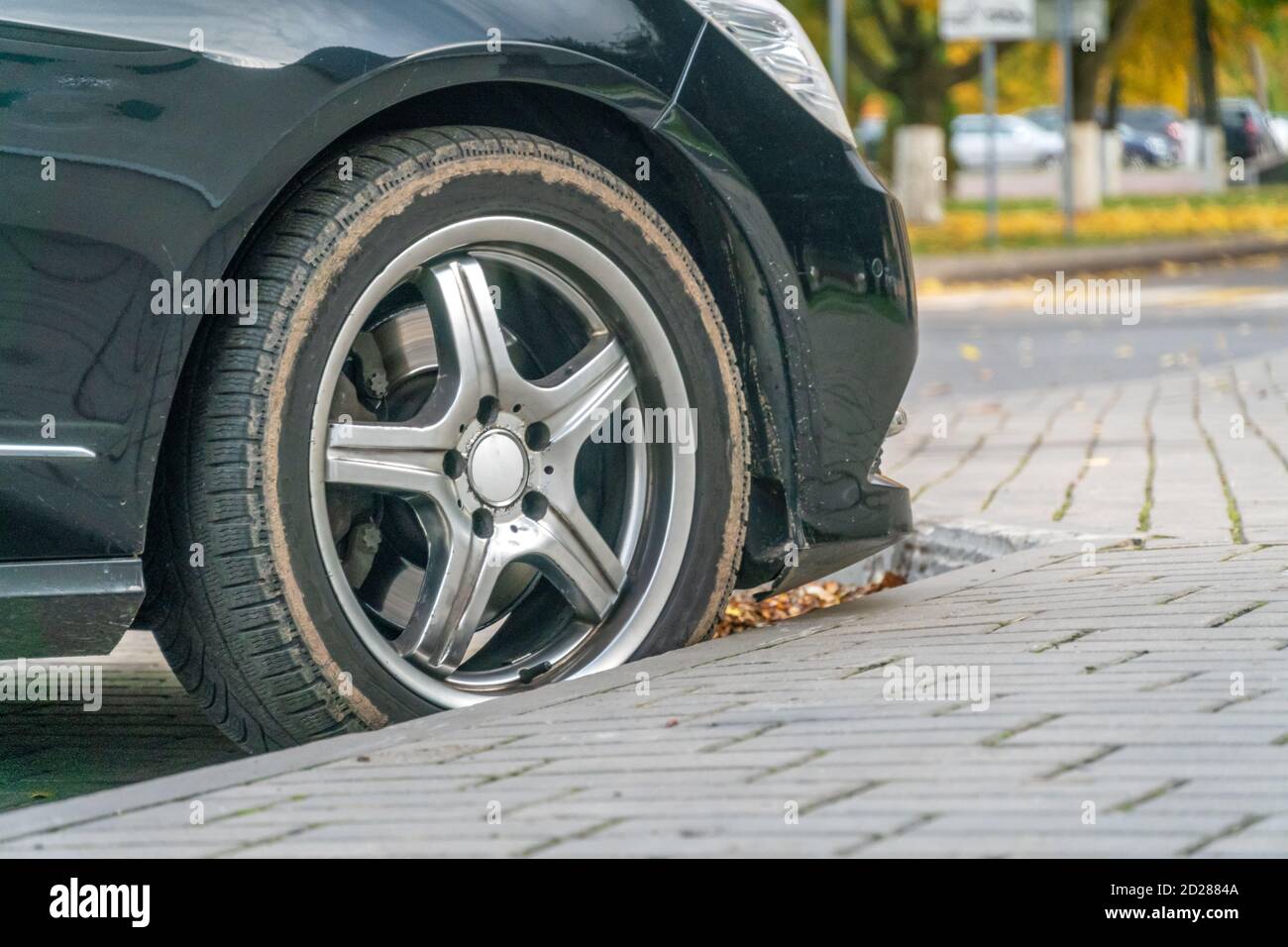 Side view of the wheel of a black car parked in autumn close up Stock ...