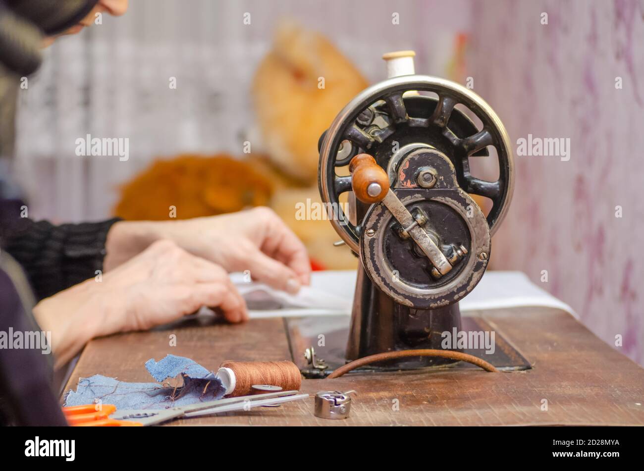 Old vintage hand sewing machine. Woman at work on a sewing machine ...