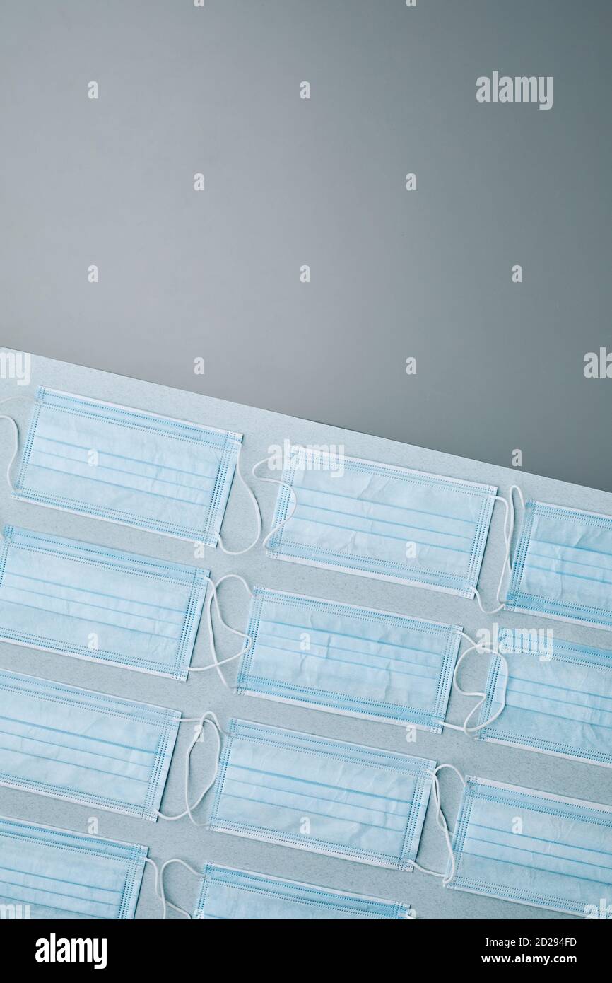 Flat lay composition of medical masks laid out in pattern over grey ...