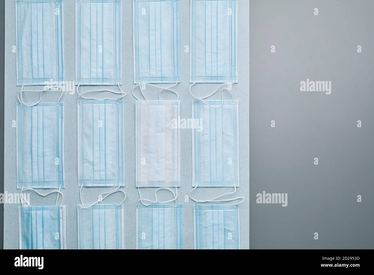 Flat lay composition of medical masks laid out in pattern over grey ...
