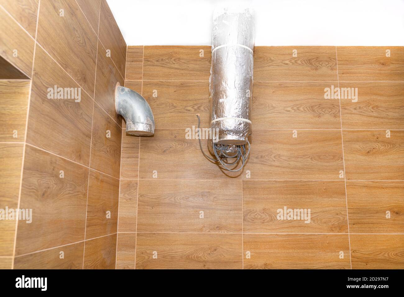 Modern gas boiler room with brown ceramic tiles imitating wood, visible ...