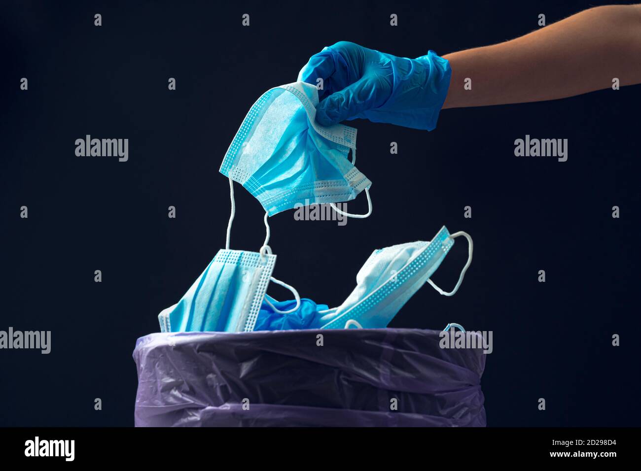 Hand putting used dirty surgical mask to a garbage bin Stock Photo - Alamy