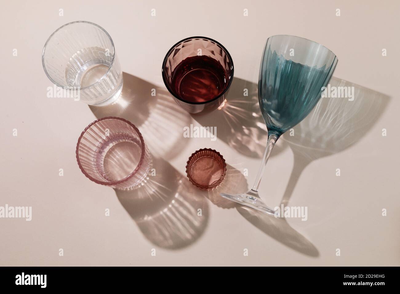 Sparcling glasses with long harsh shadows on biege background. Summer ...