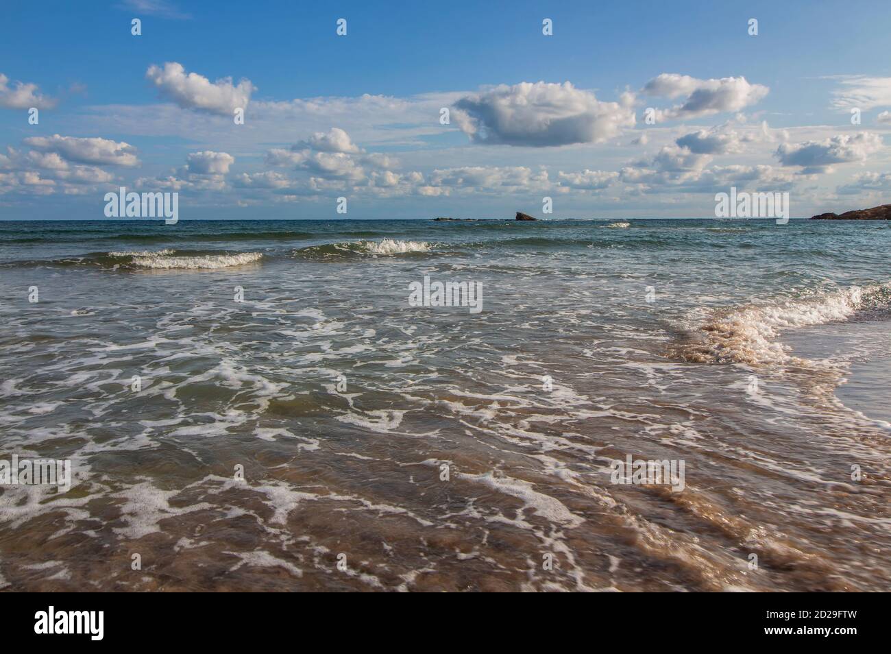 Seascape. The shallow waters on the beach under a beautiful cloudy sky ...