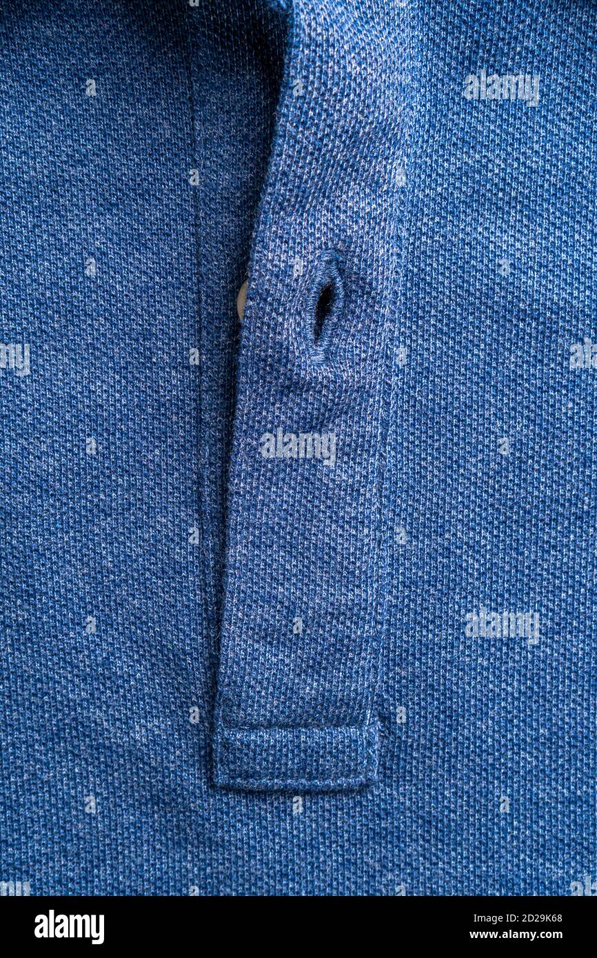 Closure of a blue polo shirt with a button close-up. Fashion background ...