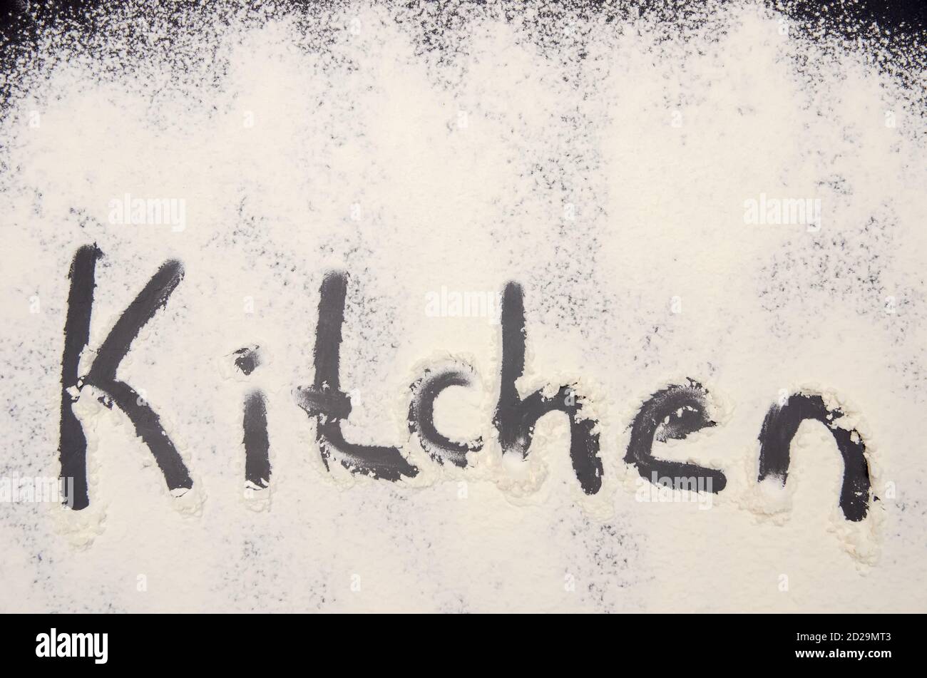 words Kitchen written on a black background with flour. Inscription ...