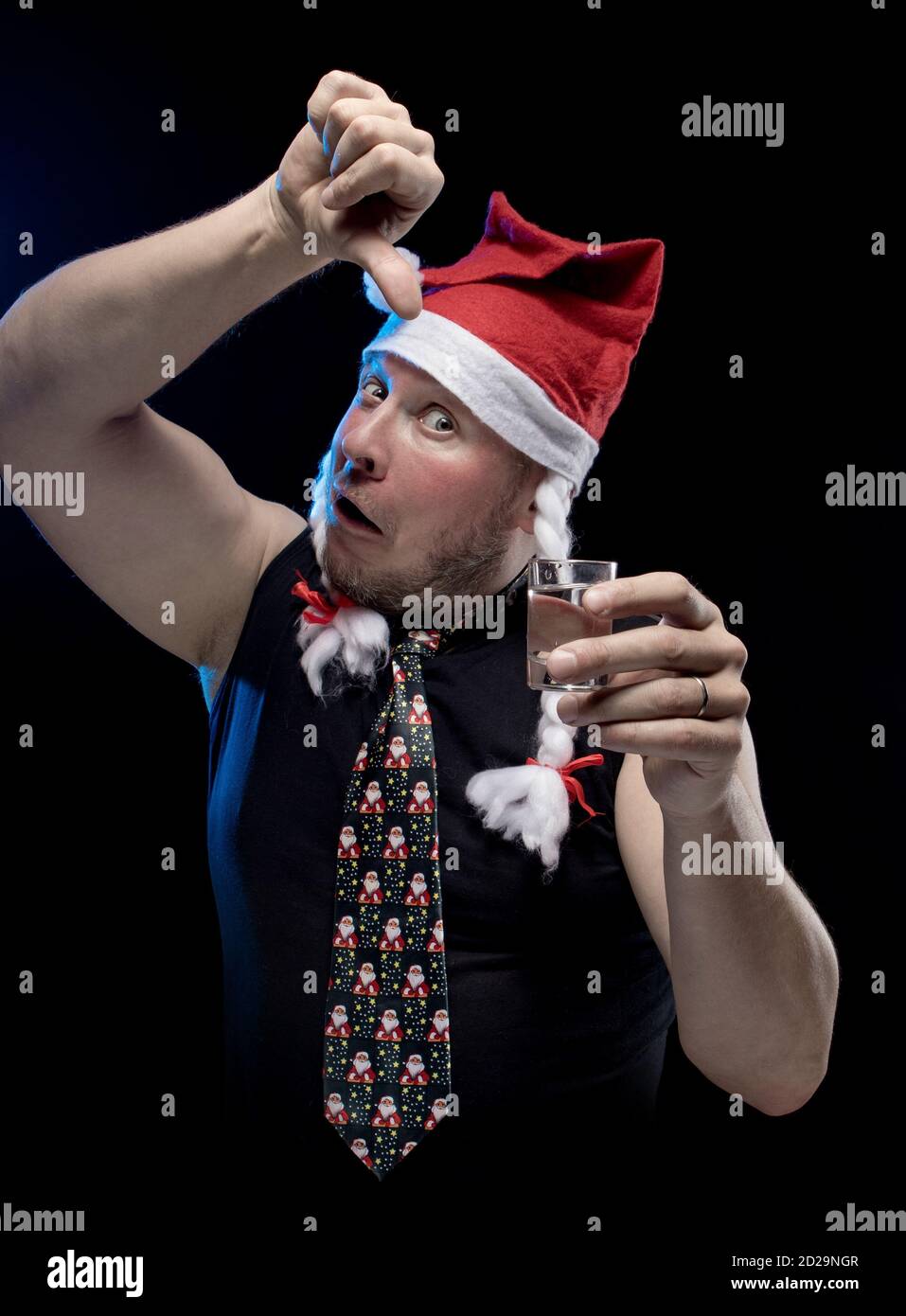 Comic actor man in cap with braids with a glass of vodka on a black ...