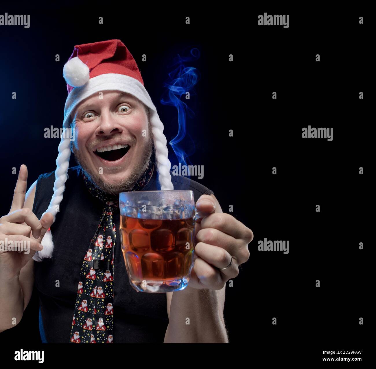 Comic actor man in cap with braids with a glass of beer on a black ...