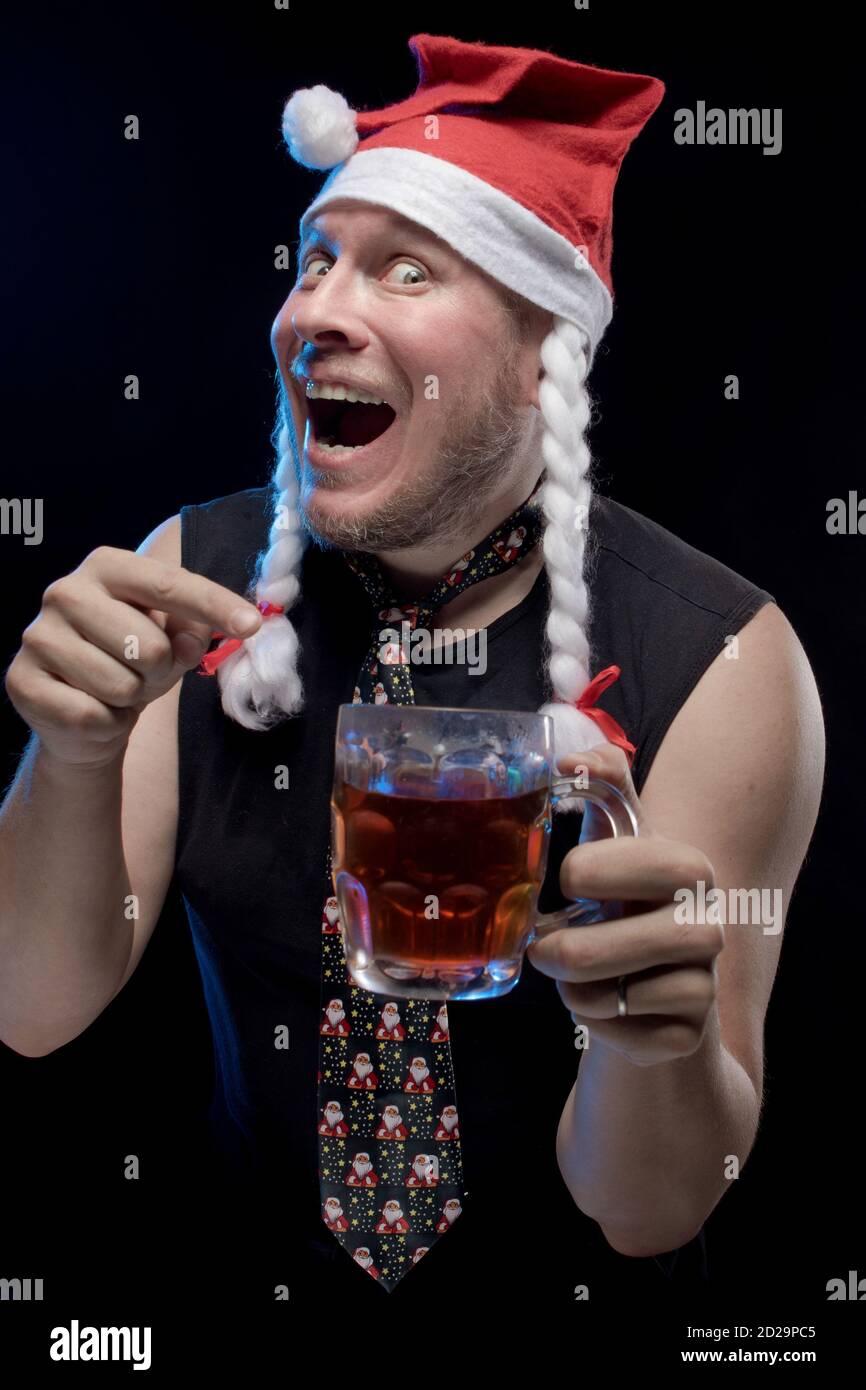 Comic actor man in cap with braids with a glass of beer on a black ...