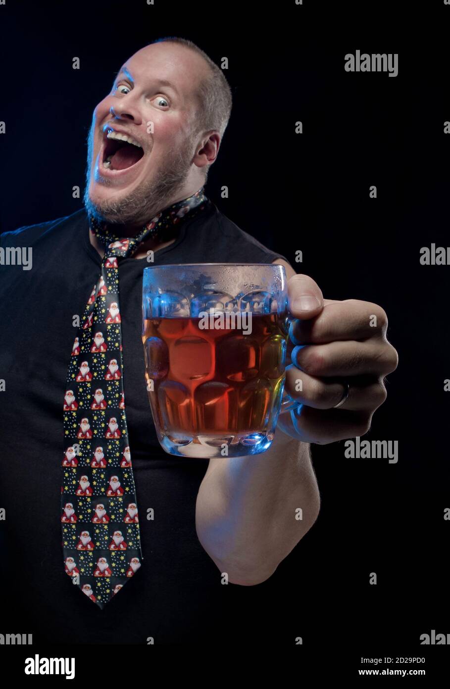 Comic actor man in cap with braids with a glass of beer on a black ...