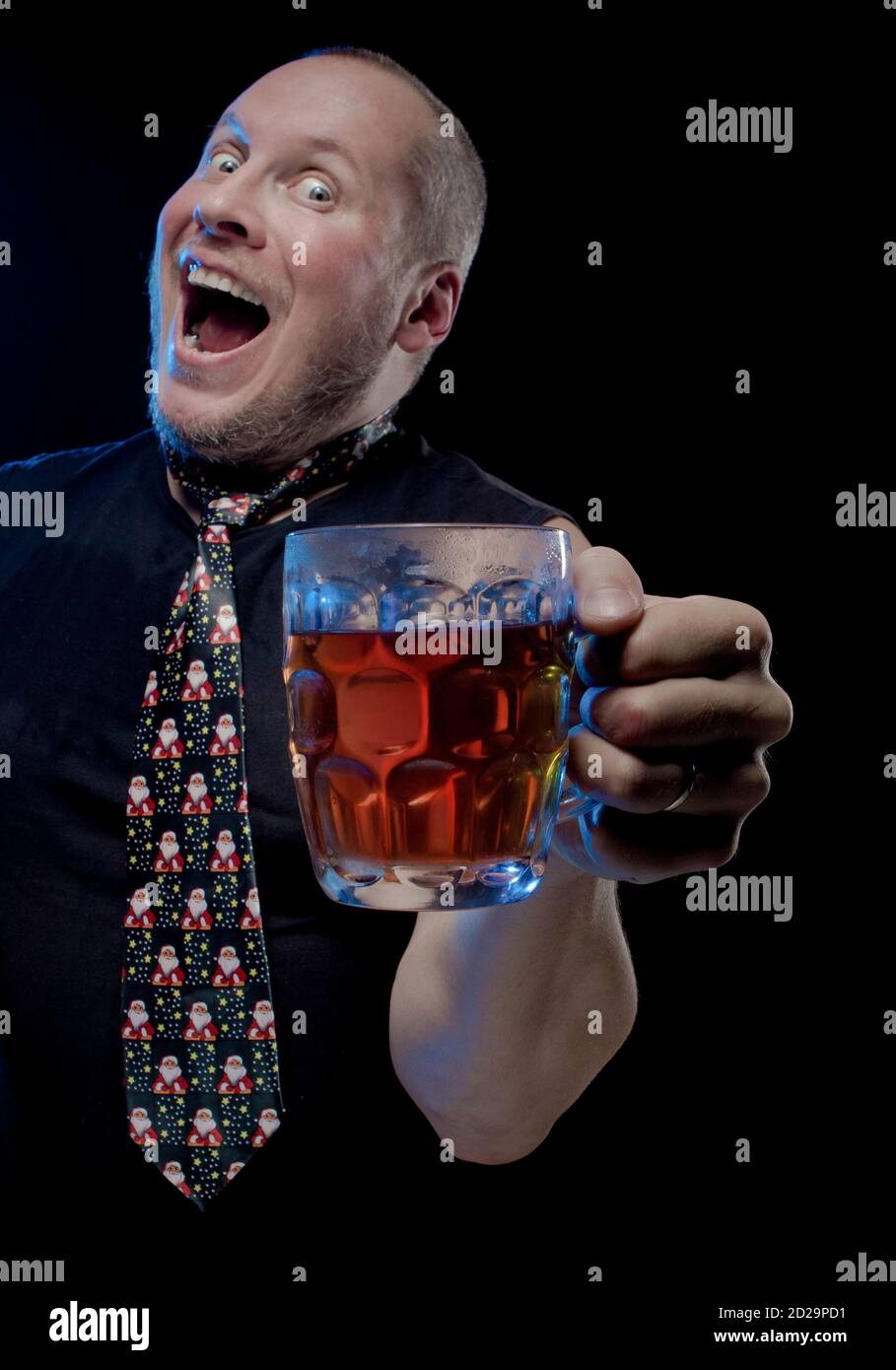 Comic actor man in cap with braids with a glass of beer on a black ...