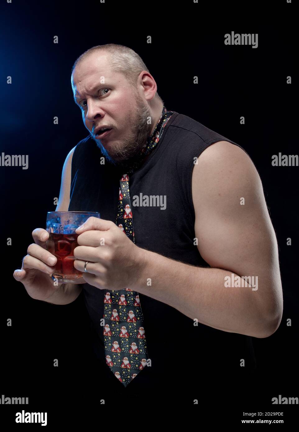 Comic actor man in cap with braids with a glass of beer on a black ...