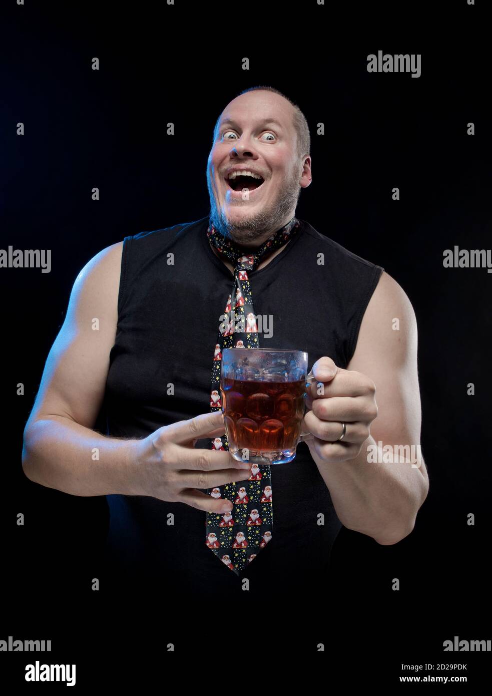 Comic actor man in cap with braids with a glass of beer on a black ...