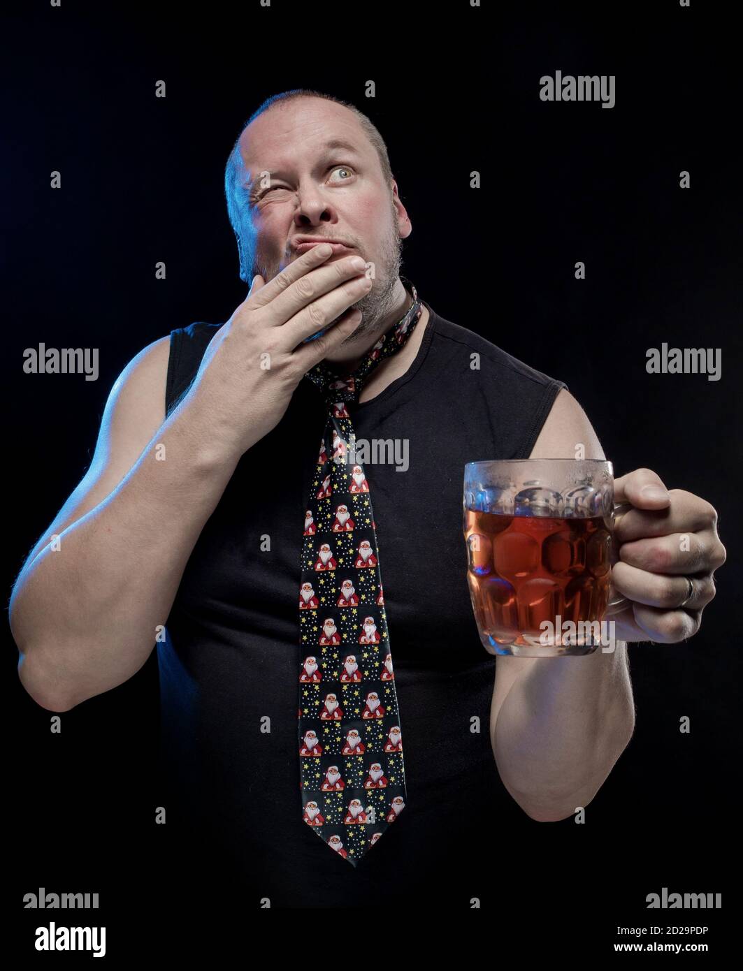 Comic actor man in cap with braids with a glass of beer on a black ...