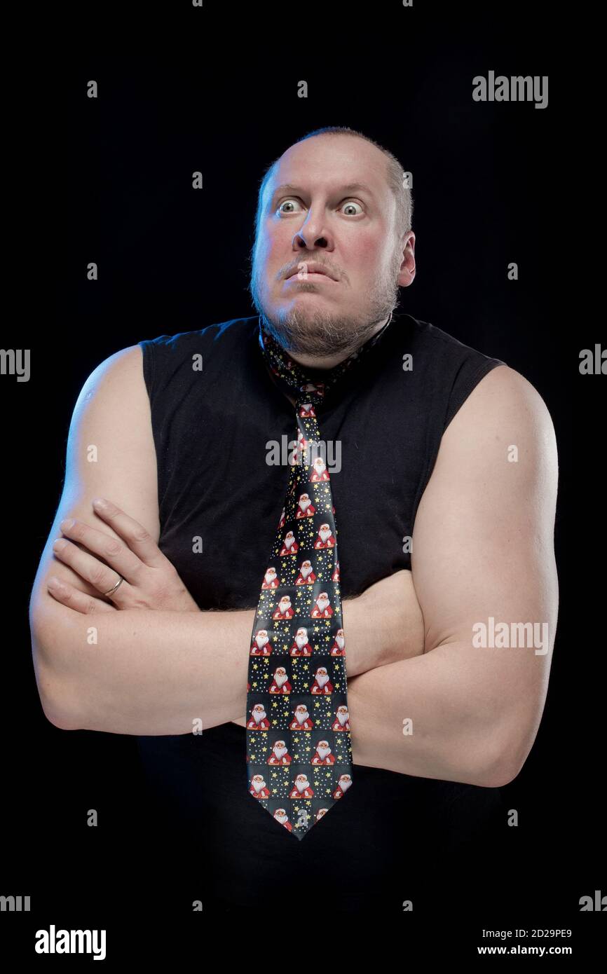 Emotional comic actor gesturing man in a tie on a black background ...