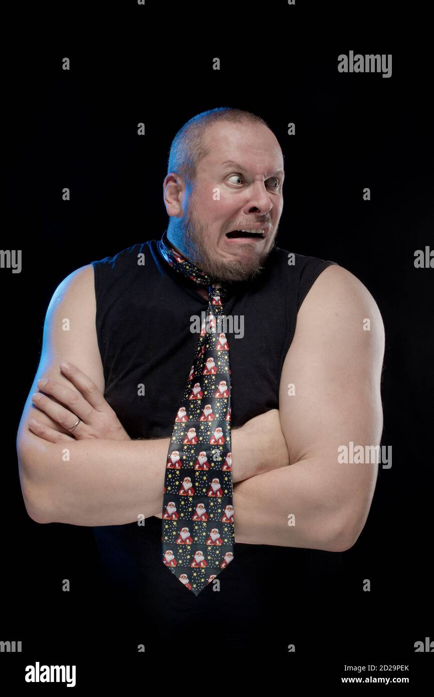Emotional comic actor gesturing man in a tie on a black background ...