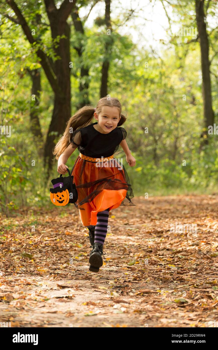 Happy little girl wearing a witch carnival costume and basket for ...