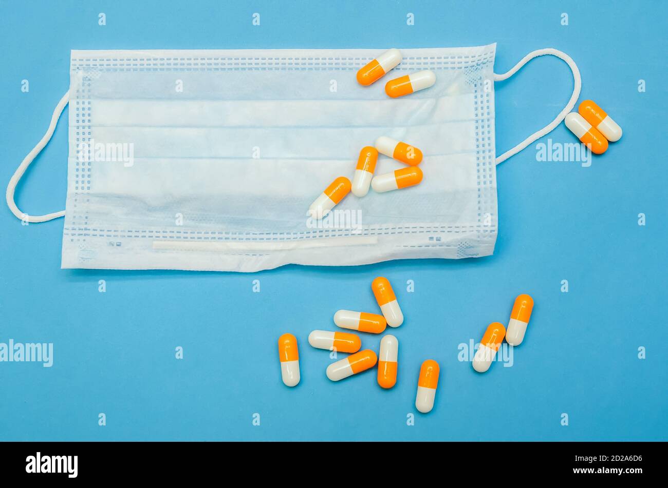 Medical mask, orange-white capsules on a blue background close-up Stock ...