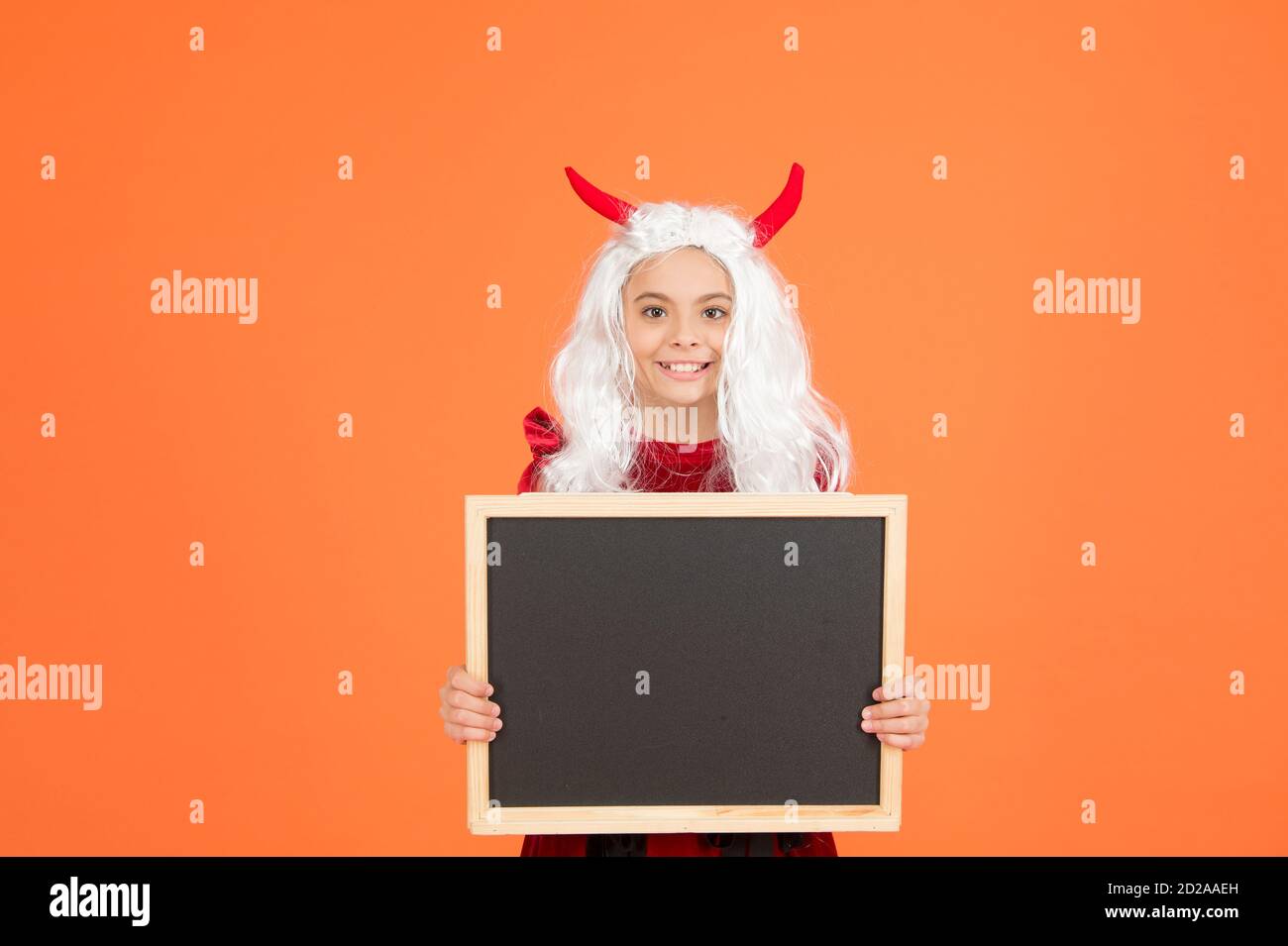 halloween devil child in imp horns hold school chalkboard for copy ...