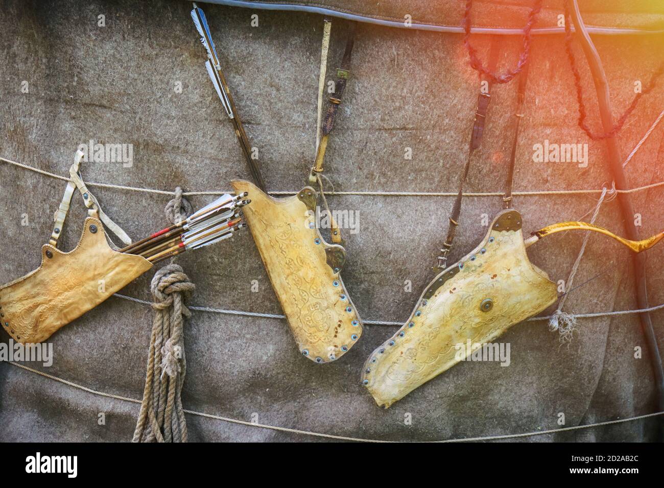 Quivers with vintage bows hanging on the wall. Weapons for hunting and ...