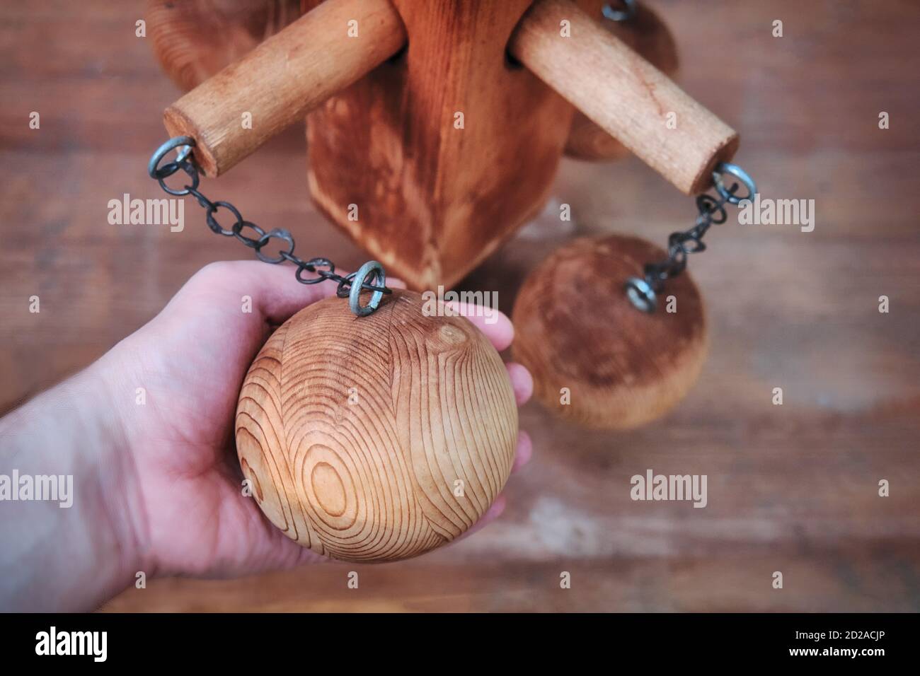 Mechanism with wooden balls on a chain. Hand holding a large wooden ...