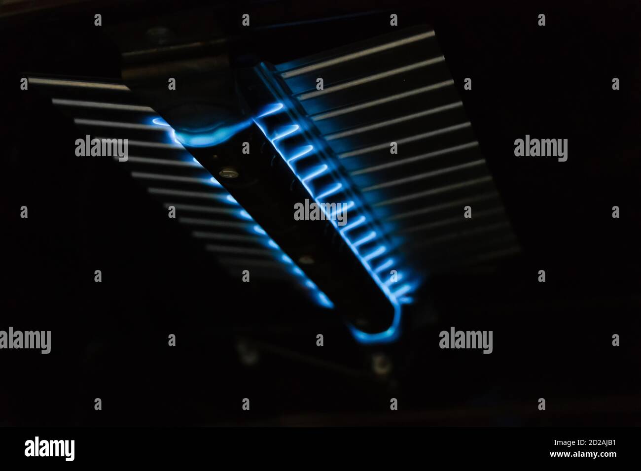 Blue flames burning inside a gas oven close up Stock Photo - Alamy