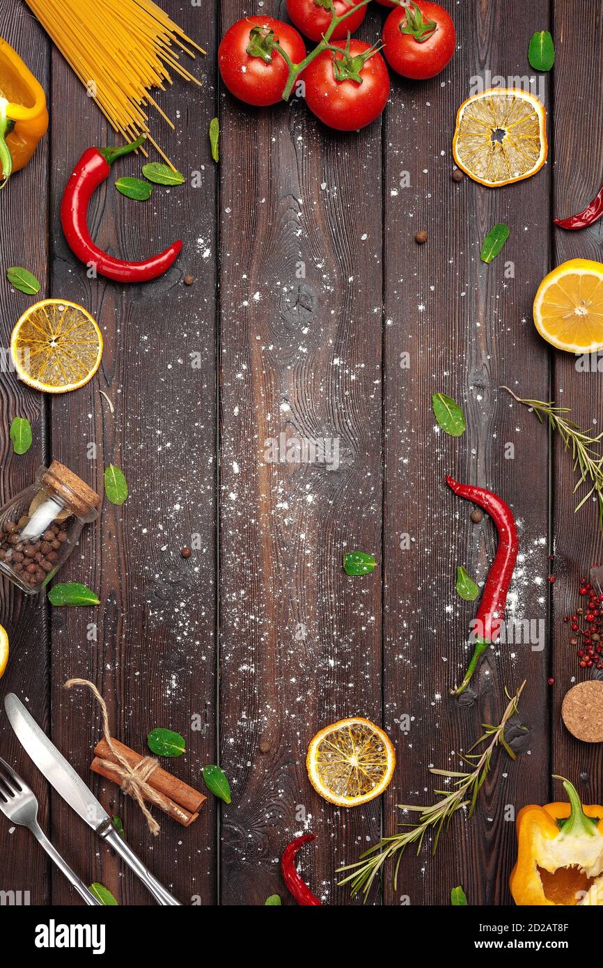 Wooden cooking background with scattered herbs and spices and copy ...