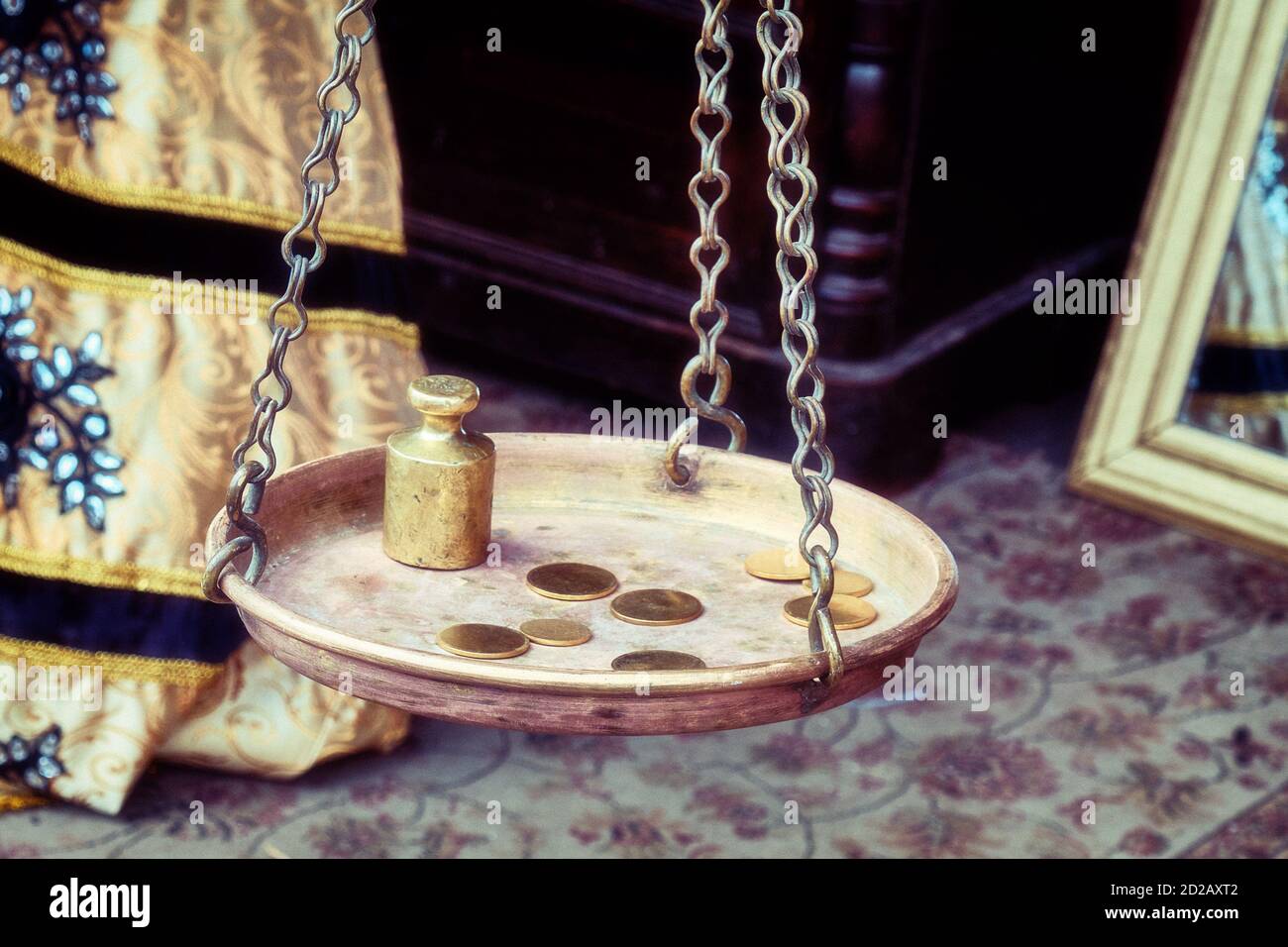 Ancient coins with a weight on the scales. Vintage interior of a wooden ...