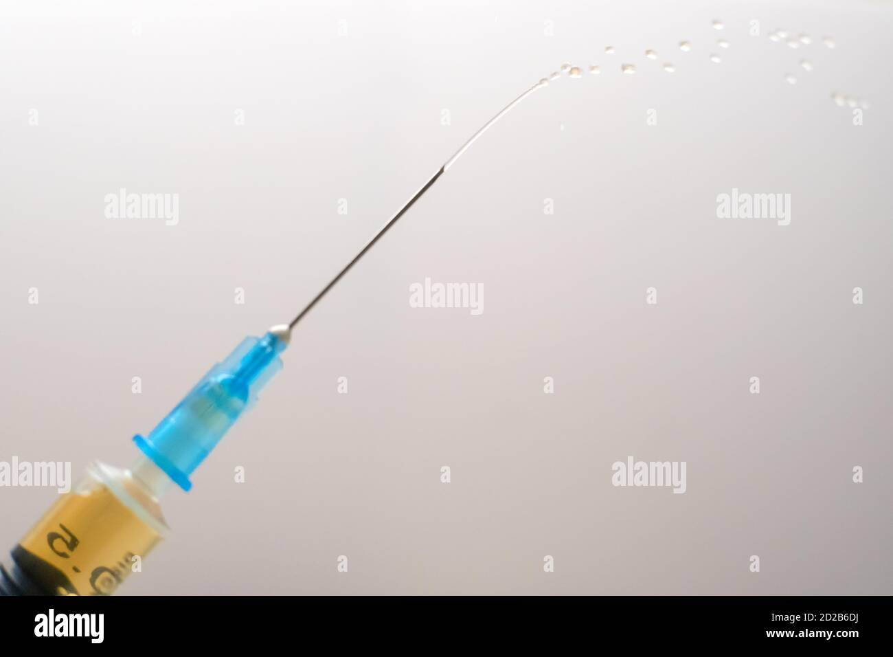 Close-up of a medical syringe with a drug on a white-gray background ...