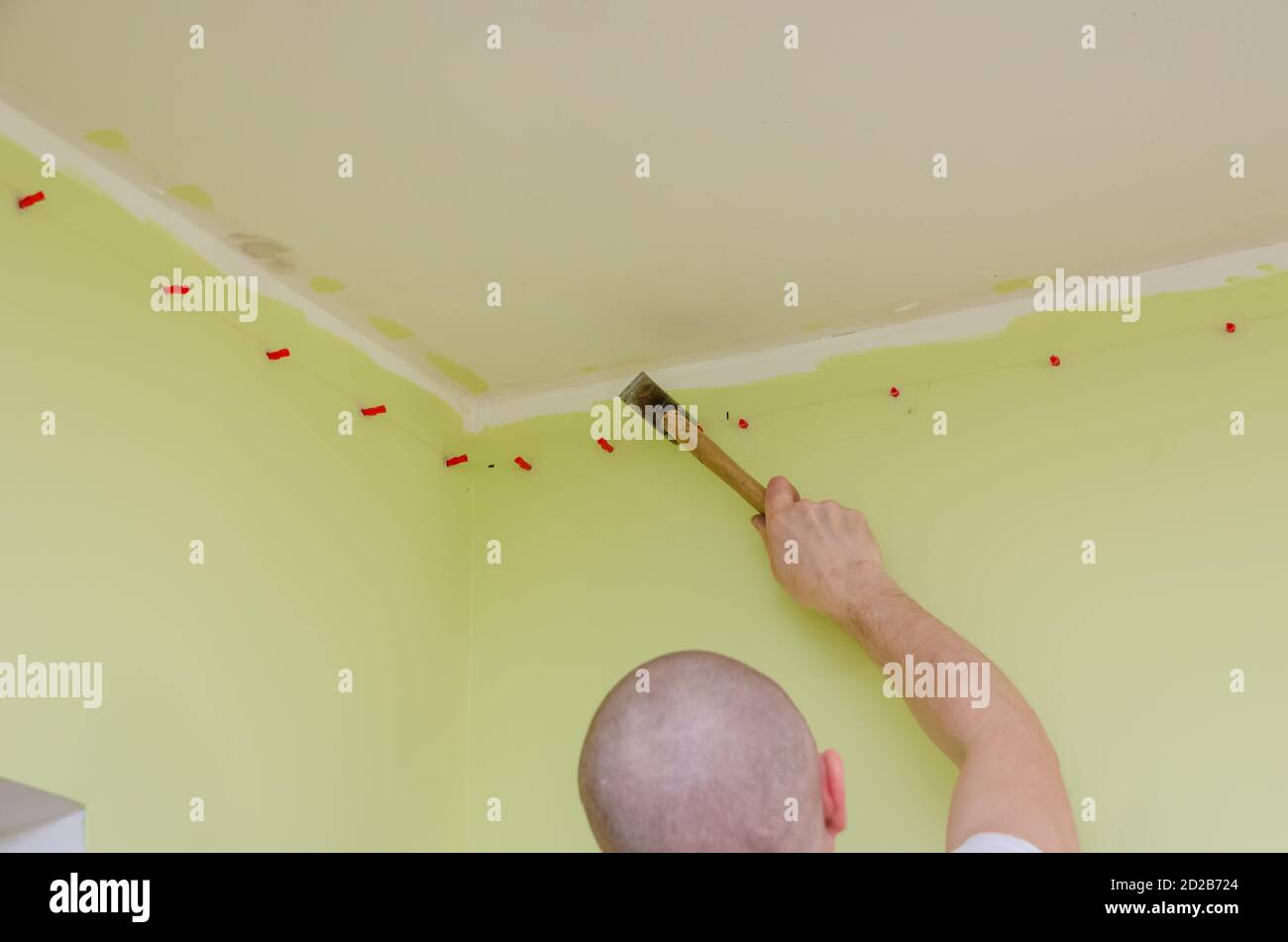 Repairman with hammer to make the hole in the wall for future ...