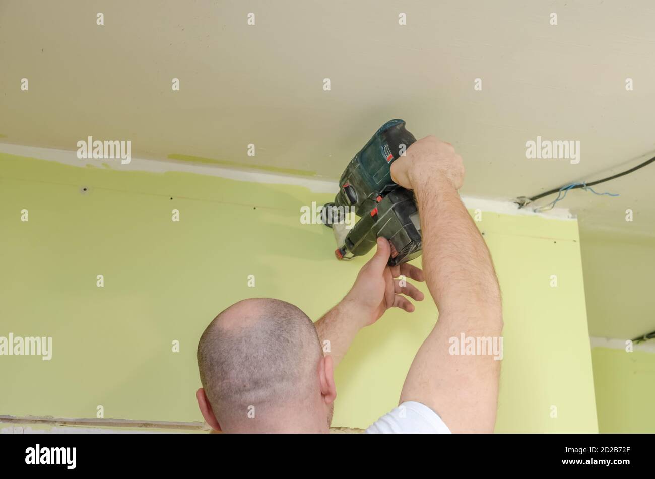 Repairman with hammer to make the hole in the wall for future ...