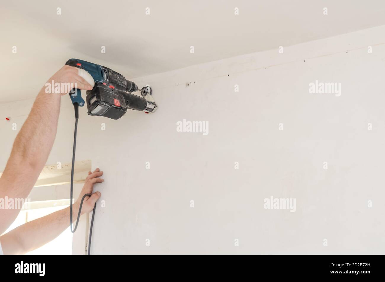 Repairman with hammer to make the hole in the wall for future ...