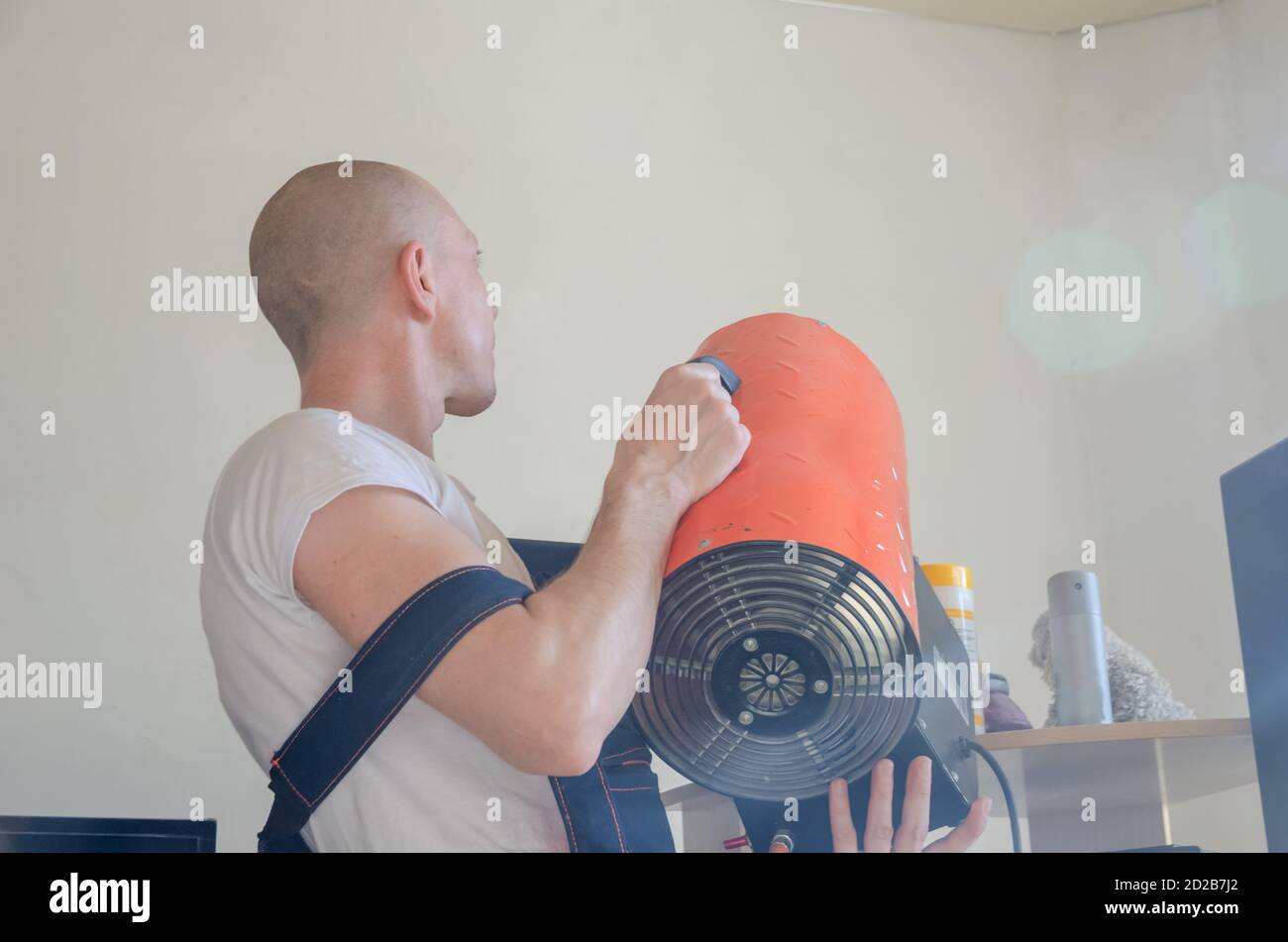 Repairers stretch the stretch ceiling with a gas heat gun Stock Photo ...