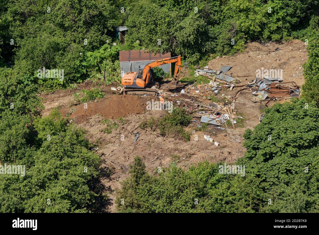 Excavator and builders destroy illegal buildings in the park Stock ...