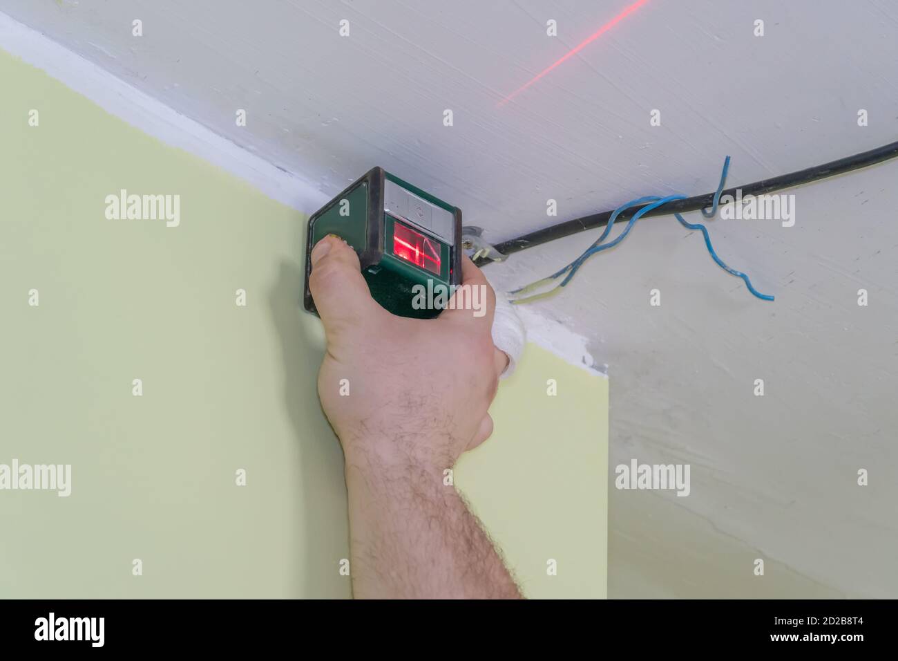 Marking the wall with a laser level for installation of a stretch ...