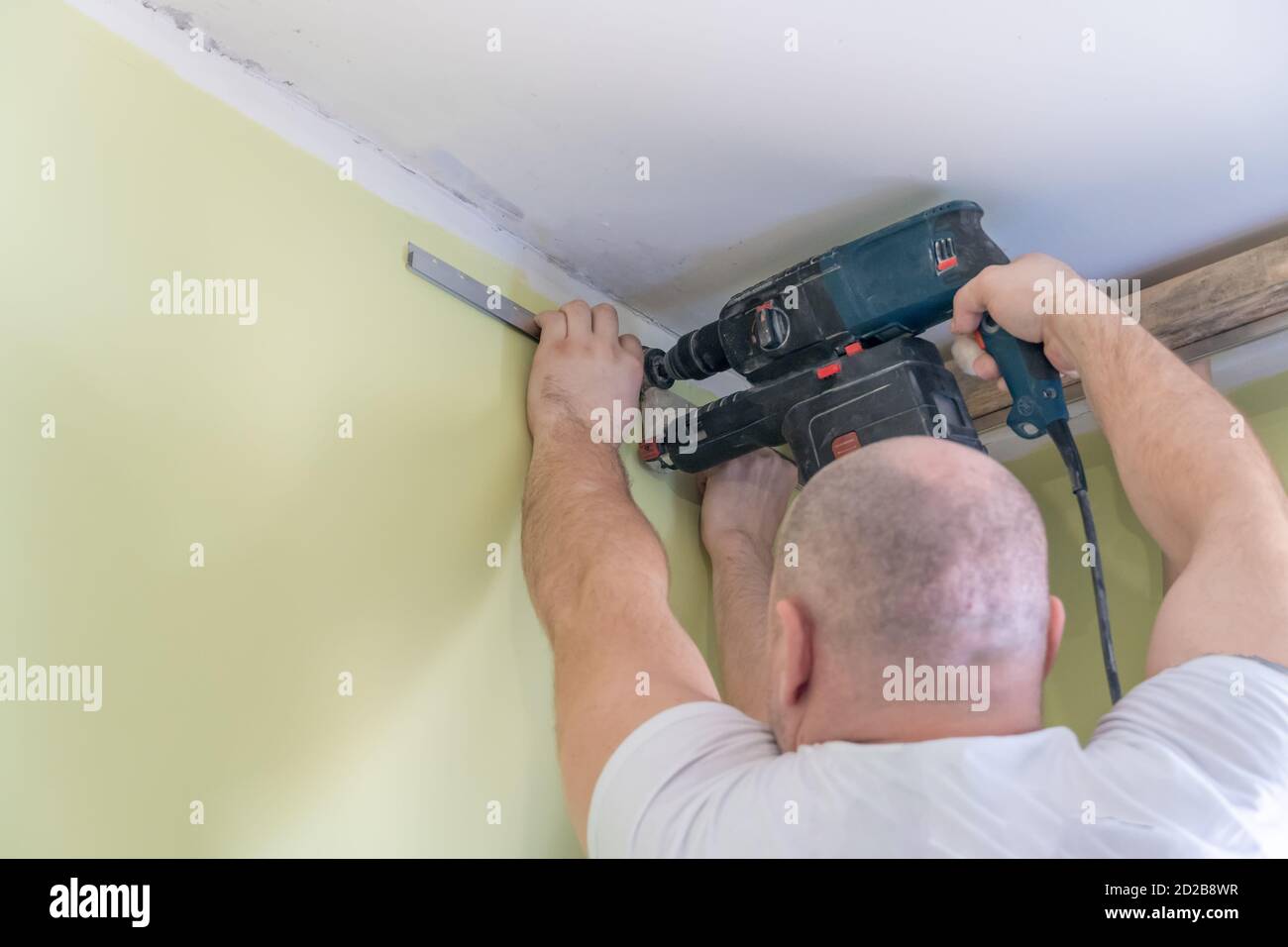 Fastening to the wall guide for stretch ceiling. Repairers make ...