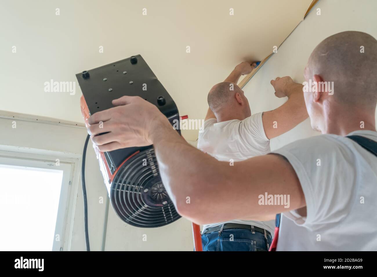 Repairers stretch the stretch ceiling with a gas heat gun Stock Photo ...