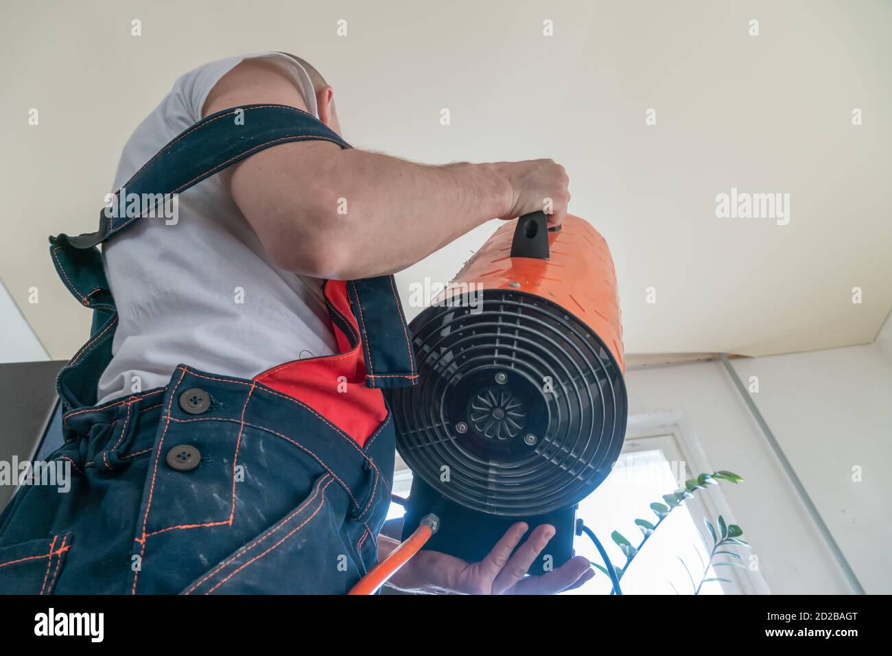 Repairers stretch the stretch ceiling with a gas heat gun Stock Photo ...