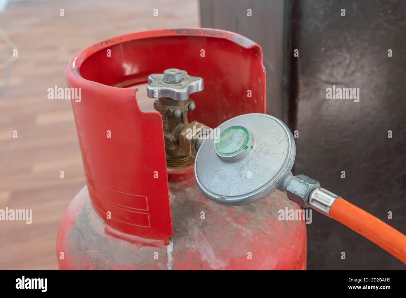 Connecting hose with flap to gas cylinder, red gas cylinder close-up ...