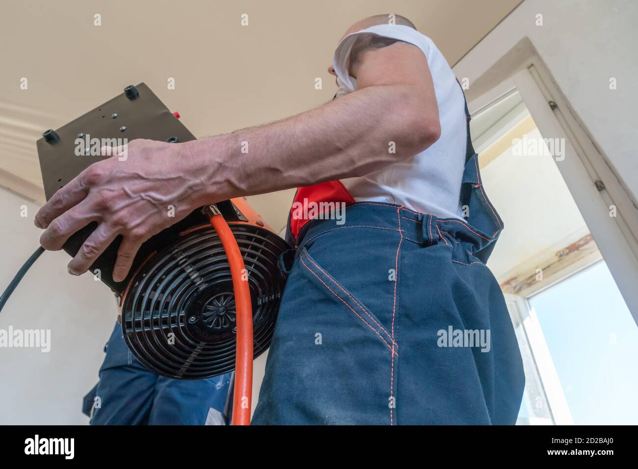 Repairers stretch the stretch ceiling with a gas heat gun Stock Photo ...